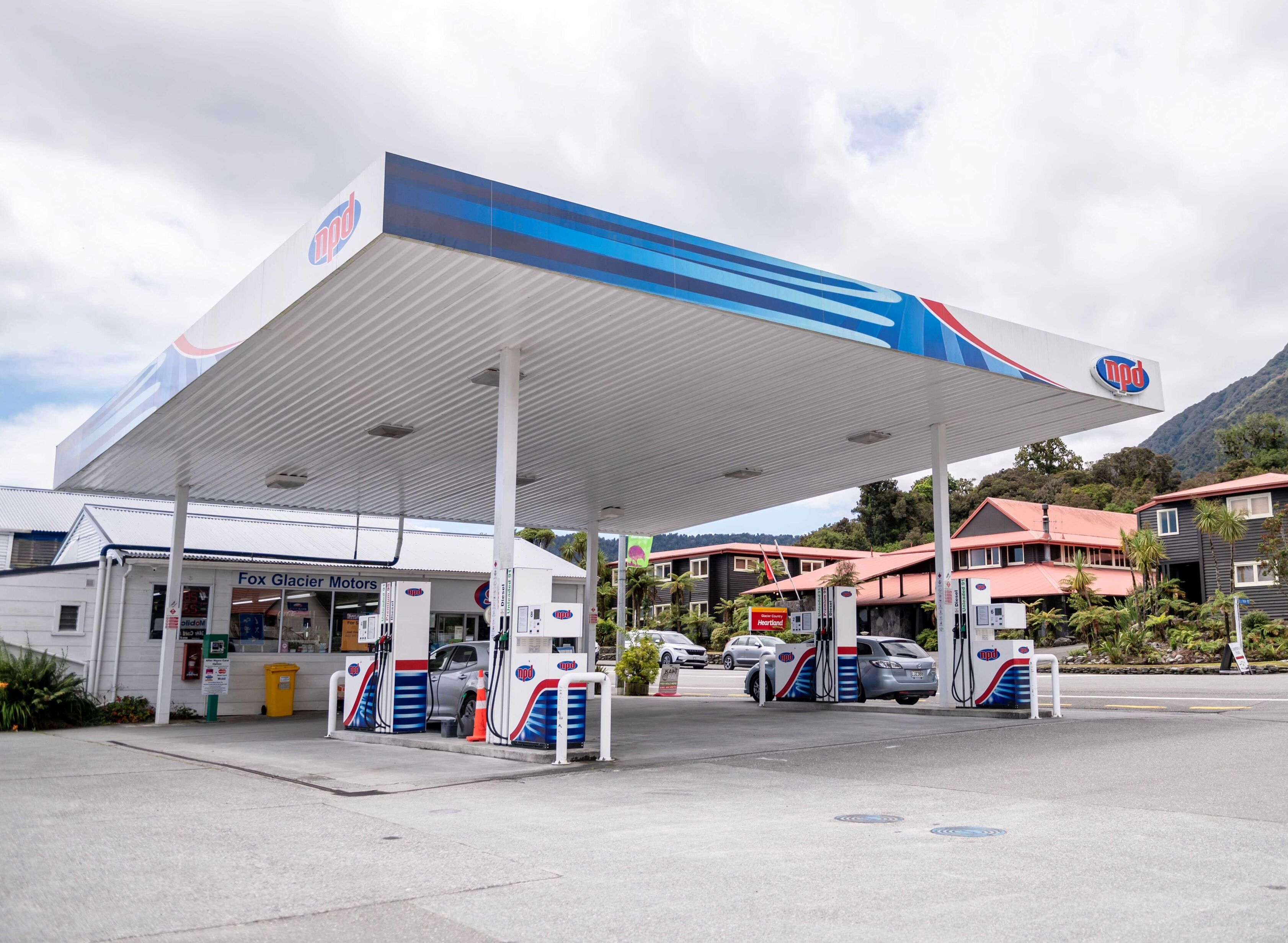 Buyers approach forecourt at fuel stop on the edge of paradise